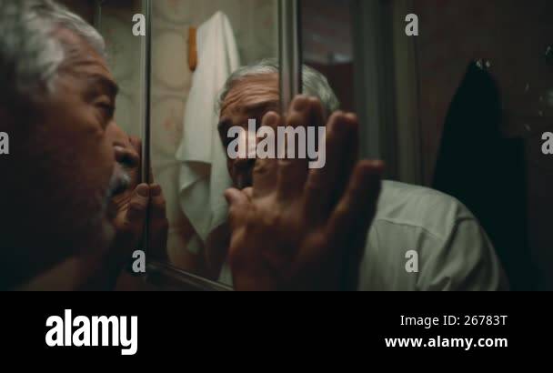 Man pressed against mirror with anguish, face twisted in fury and ...