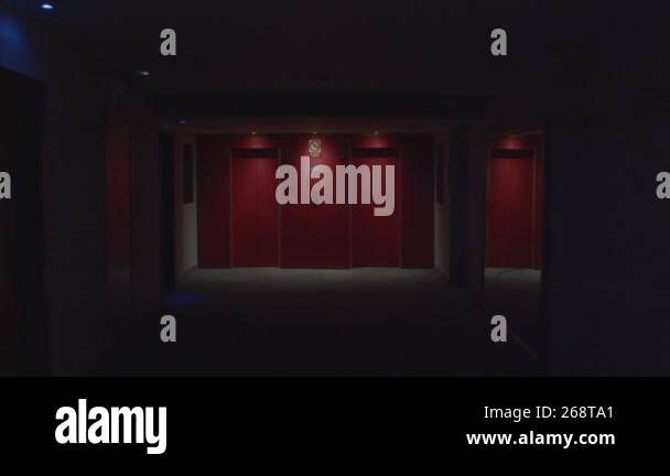Dark corridor revealing vibrant red elevator doors, creating ...