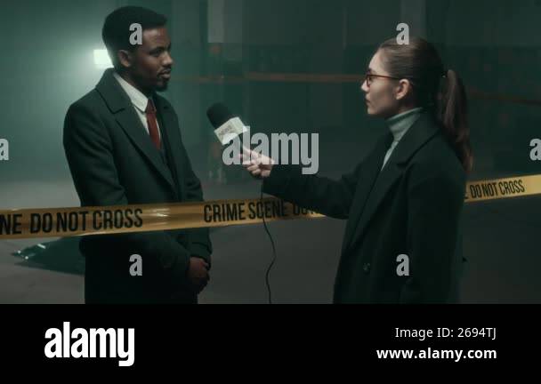 Medium lowkey shot of young Caucasian female reporter asking young ...