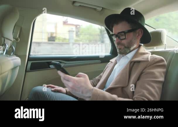 Stylish millionair in retro english clothes driving in a luxury car ...