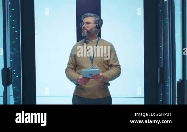 A man with a headset is standing in a contemporary technology ...