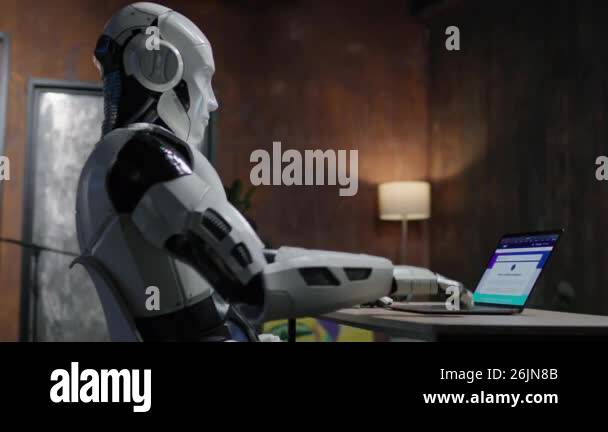 360 degree tracking shot of busy android sitting at desk and typing on keyboard of laptop. White ...