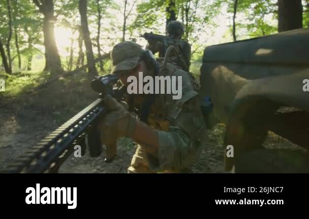 Two soldiers in military uniform and orange glasses moving in green ...