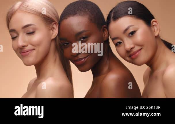 Three women stand closely together, showcasing their unique beauty and ...
