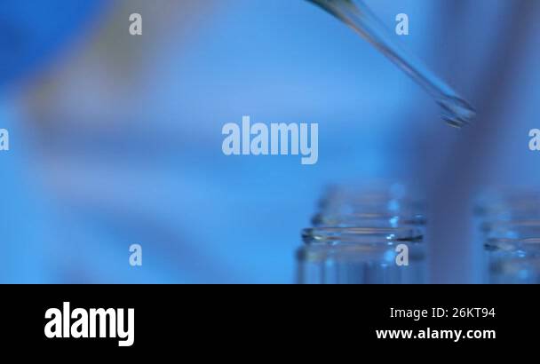 Dripping liquid into glass test tubes during a laboratory experiment ...