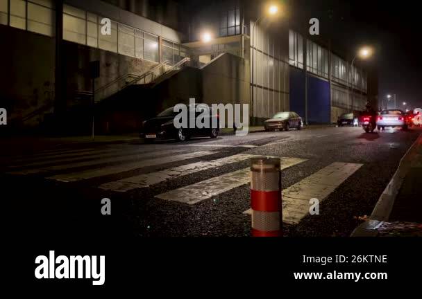 Flashing light signal on a pole near a pedestrian crossing at night ...