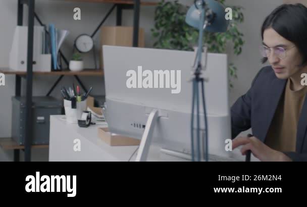 Asian office worker using computer typing pointing at screen with happy ...