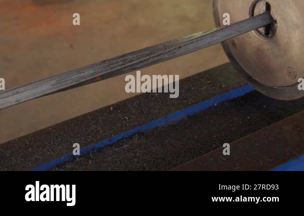 Twisted metal square rod. The rod is placed in a hydraulic torsion ...