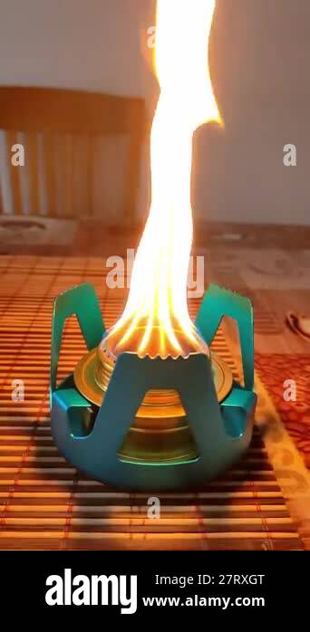 An alcohol stove flame burning brightly on a table indoors. The image ...