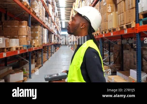 Logistics worker scanning packages in a warehouse using a barcode ...