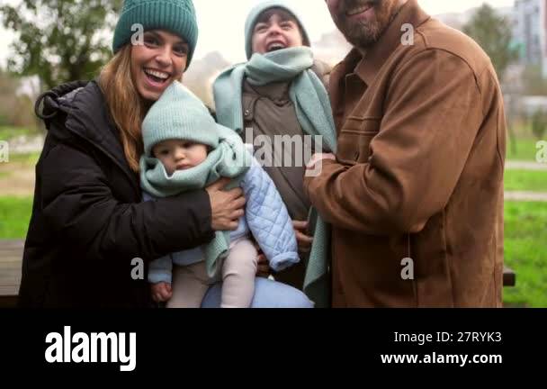 Bundled up family members sharing warm, joyful moment together ...