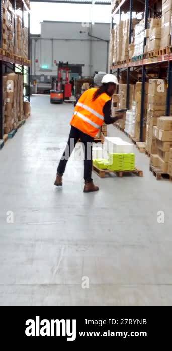 Warehouse workers utilize barcode scanners and pallet jacks for ...