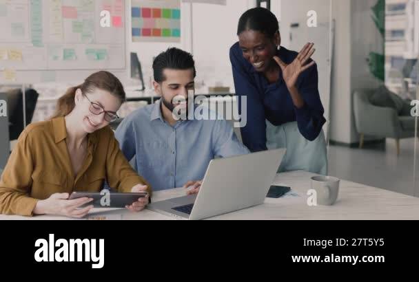 Happy teammates working on task in office use laptop, giggling during ...