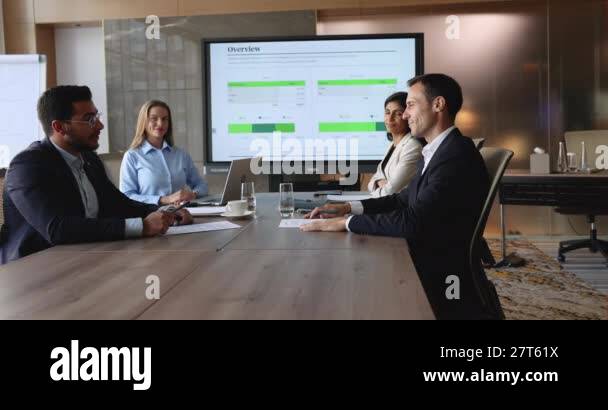 Two parties represented by business professionals reviewing, signing ...