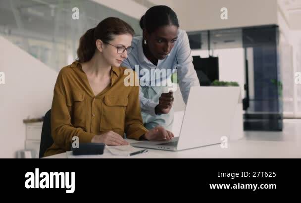Two women colleagues collaborating, engaging in discussion, working ...