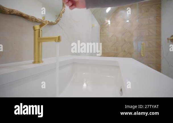 Man hand open and closed the golden water tap to save water. Turning on ...