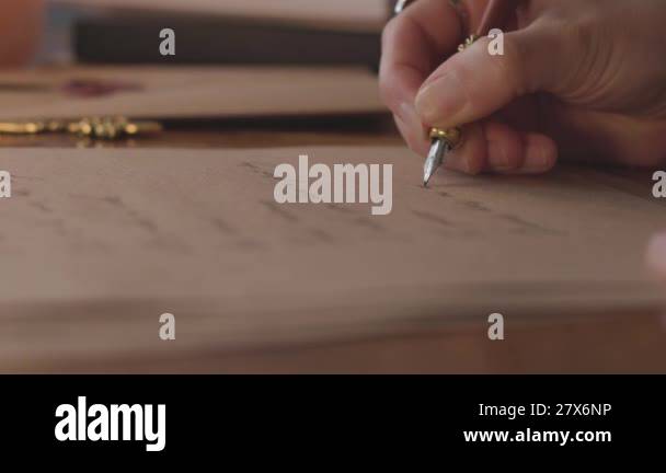 Close up of girl's hand writing calligraphy with ink pen. Professional ...