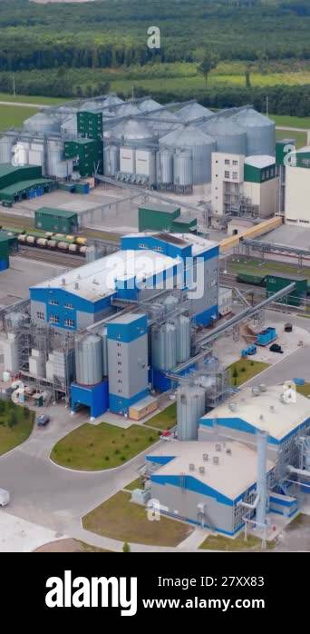 Beautiful agriculture complex among green landscape. Grain elevators ...
