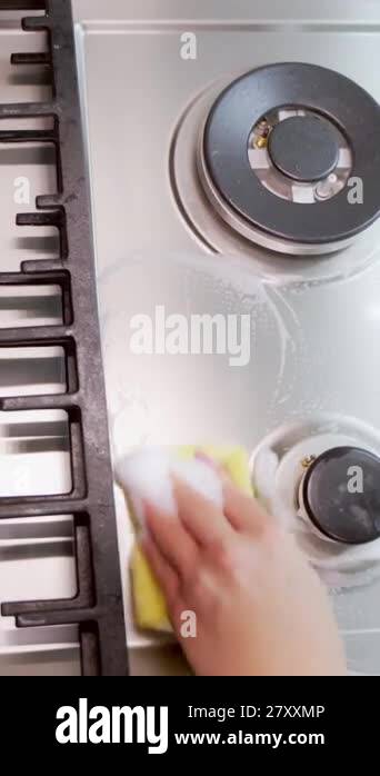 Cleaning of gas cooker, close up. Close up of cleaning gas stove in the ...