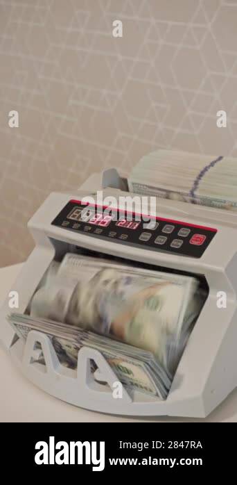 A currency counting machine processes stacks of cash efficiently in a ...