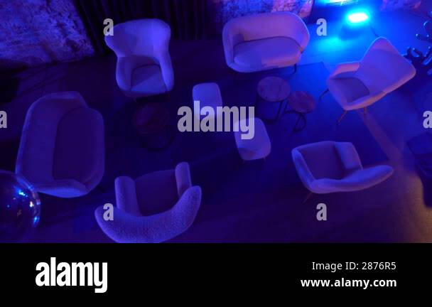 A top-down view of cozy white lounge chairs, sofas, and small round ...