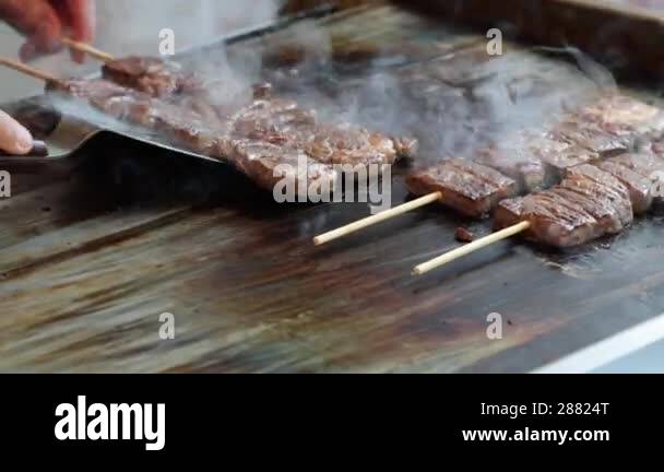 Chef grilling skewered Japan Wagyu beef or meat with a fire blowtorch ...