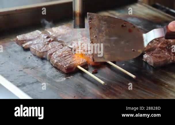 Chef grilling skewered Japan Wagyu beef or meat with a fire blowtorch ...