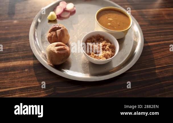authentic indian traditional food bati served in steel plate from top ...
