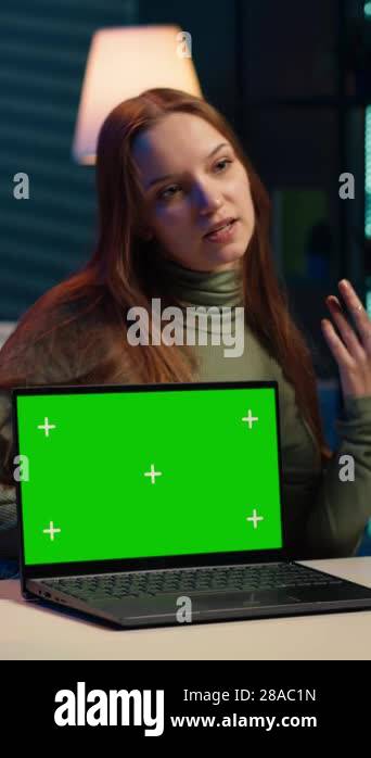 Vertical video Young entertainer presenting green screen laptop from ...