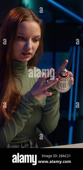 Vertical video Young influencer filming review of light bulb able to ...
