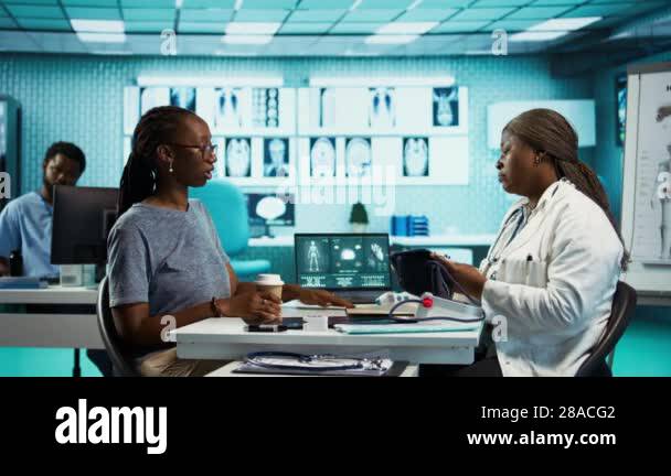 Black medic practitioner takes blood pressure with a blood pressure ...