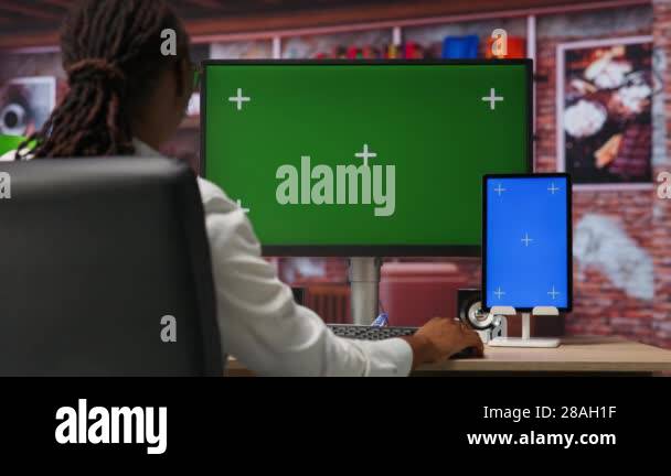 Freelancer in home office using green screen PC and mockup tablet to ...