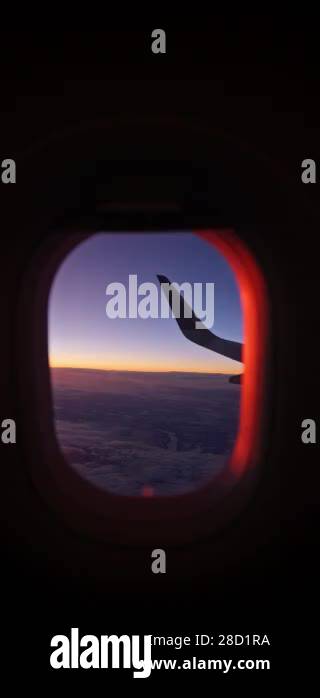 Sunset sky clouds with dramatic light view through airplane window over ...