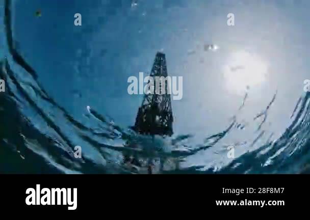 An enthralling underwater view of an oil rig, beautifully illuminated ...