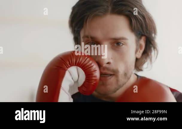 A young man is engaged in an intense boxing workout at home ...