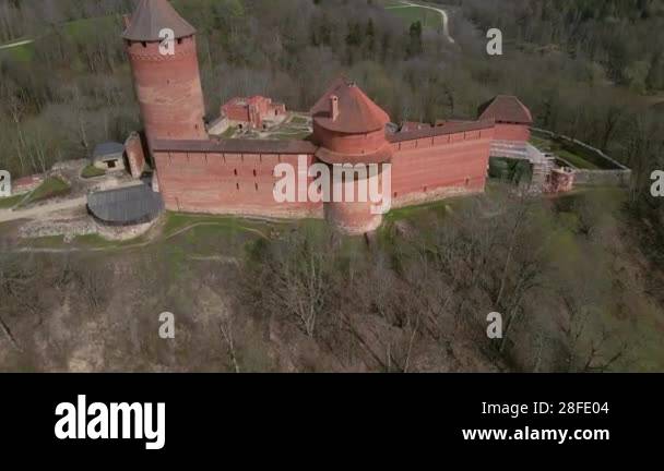 Medieval red brick castle featuring multiple towers, a cylindrical ...