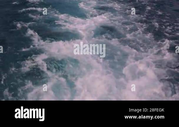 Ocean waves display frothy whitecaps and swirling blue water, with ...