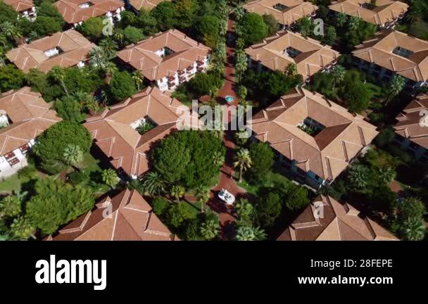 An aerial view captures a residential area with terracotta tiled roofs ...