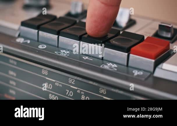 Close-up of a finger pressing the play button on a retro cassette ...