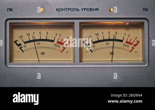 Close-up of vintage VU meters with needles moving slightly. Lighted ...