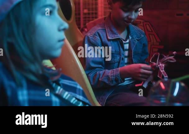 Medium side shot of two young boys hanging out together at arcade on ...