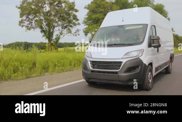 Cargo minibus drives on the highway in sunny weather. White Cargo ...