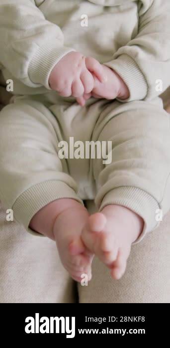 Close-up image of baby sitting in mothers arms and playing with her ...