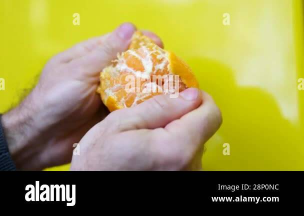 Peeling Orange. Female hands peeling orange fruit. Woman removing ...