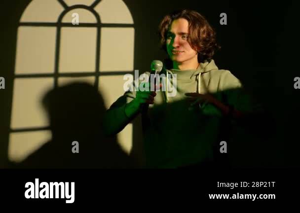 Person with mic on colorful studio background. Portrait of man in green ...