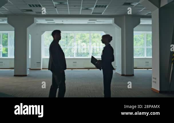 Couple successful business partners silhouettes making deal at empty ...