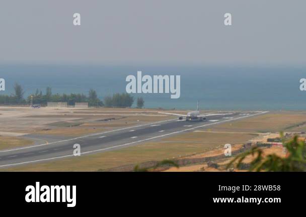 Shot, wide-body passenger jet on the runway, ready for takeoff. Sea ...