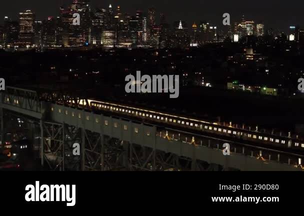 Aerial view of New York City at night. A subway train passes in the ...