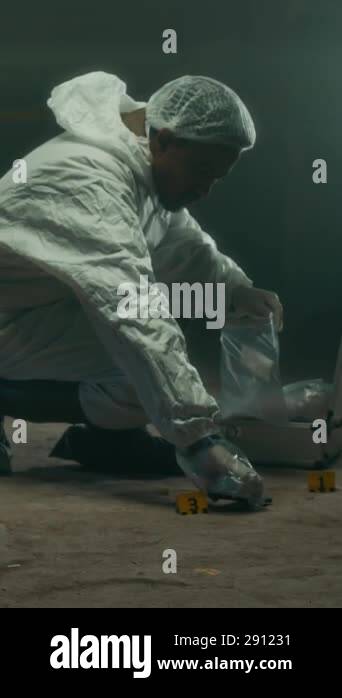 Vertical side view lowkey shot of Black male forensic expert in ...