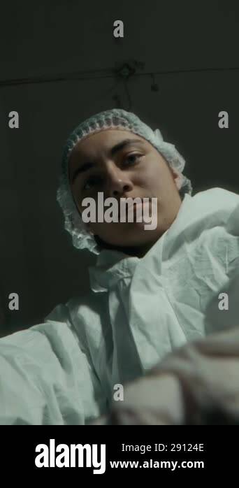 Vertical bottom view lowkey shot of young Caucasian female forensic ...